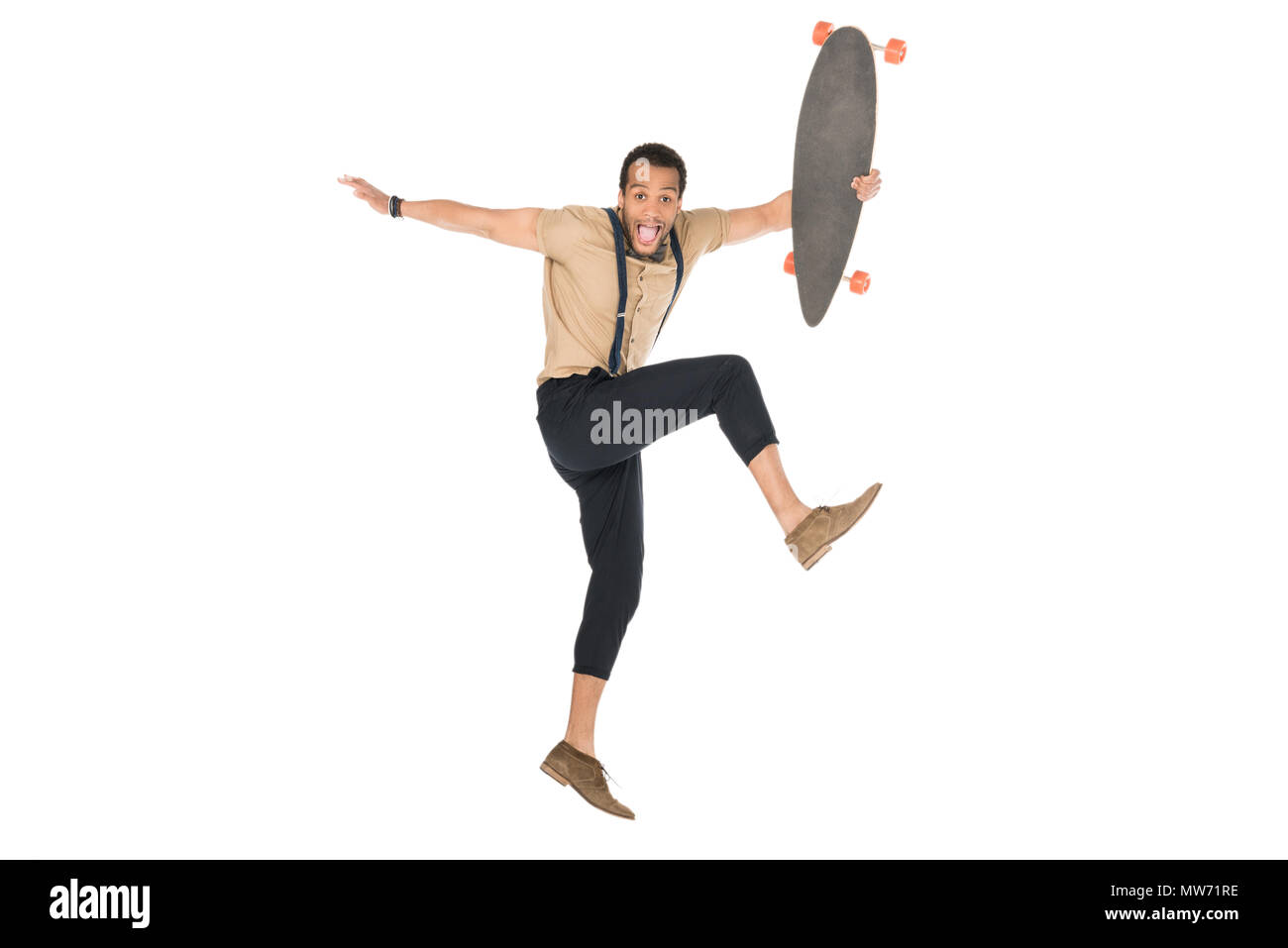 Happy young man having fun with skateboard and smiling at camera ...