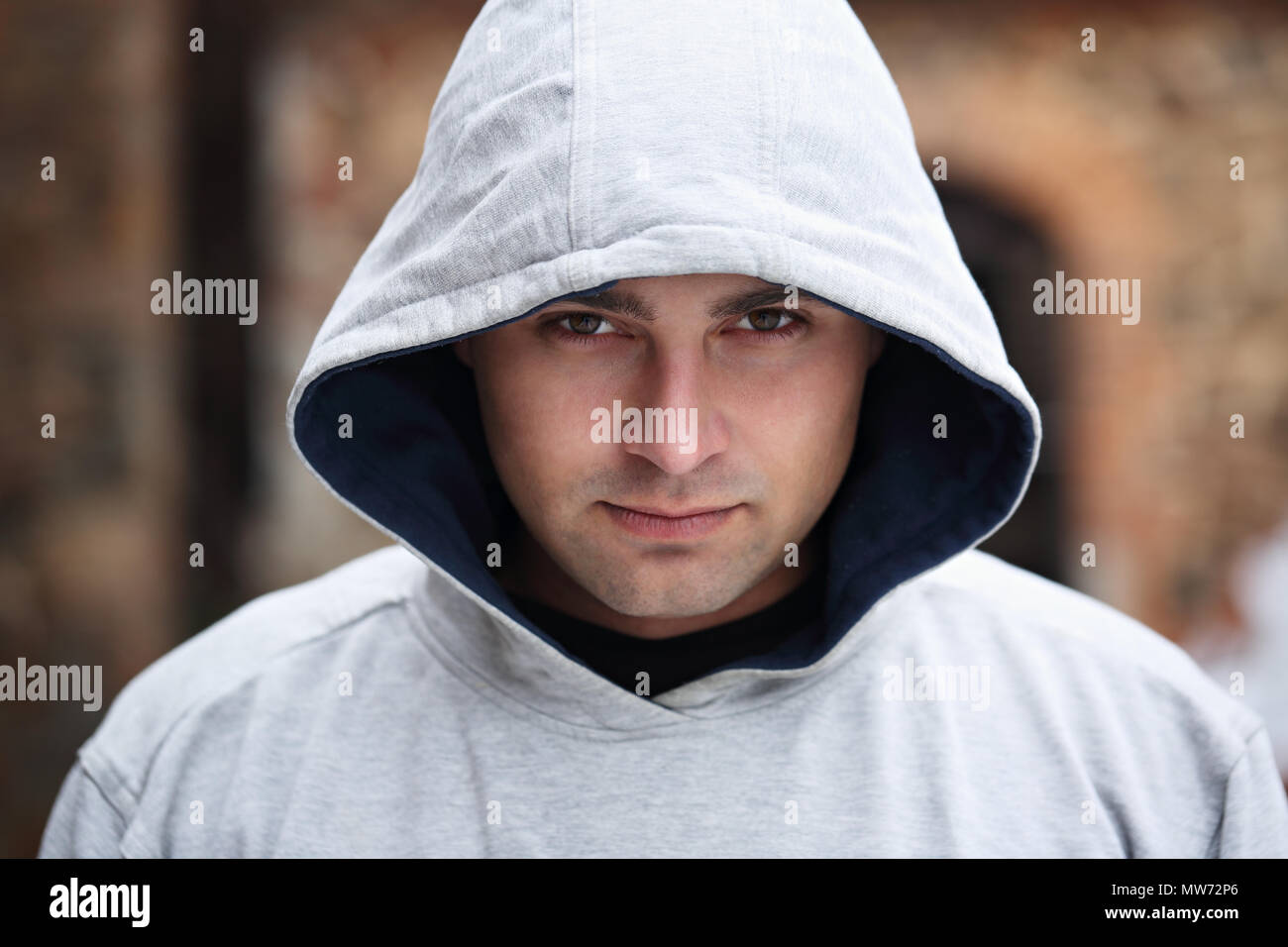 A handsome young man in a gray hood Stock Photo - Alamy