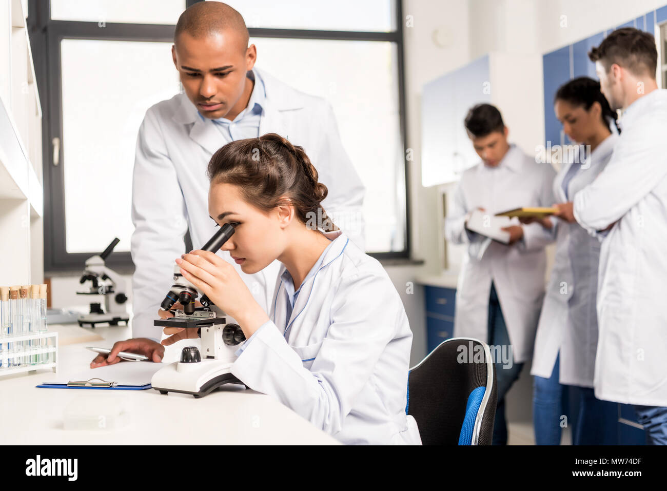 Female scientist during work with microscope at modern biological ...