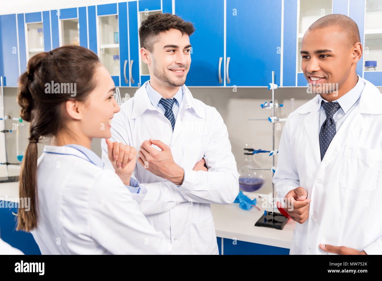 group of medical workers in lab coats, discussing work in laboratory ...