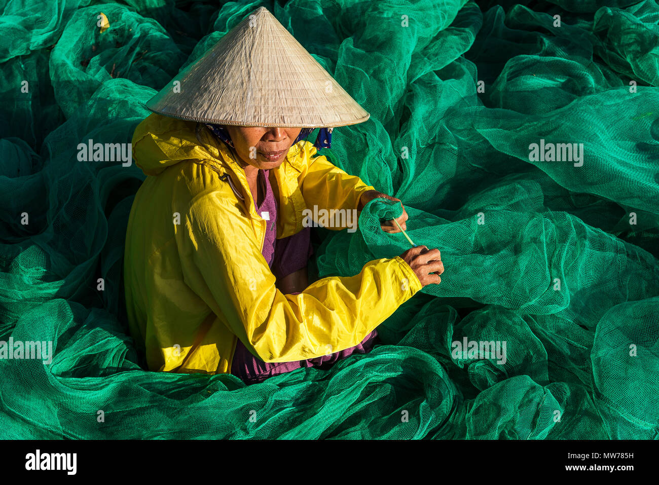 Woman weaving fishing nets outside her house in Mui Ne, Vietnam Stock ...