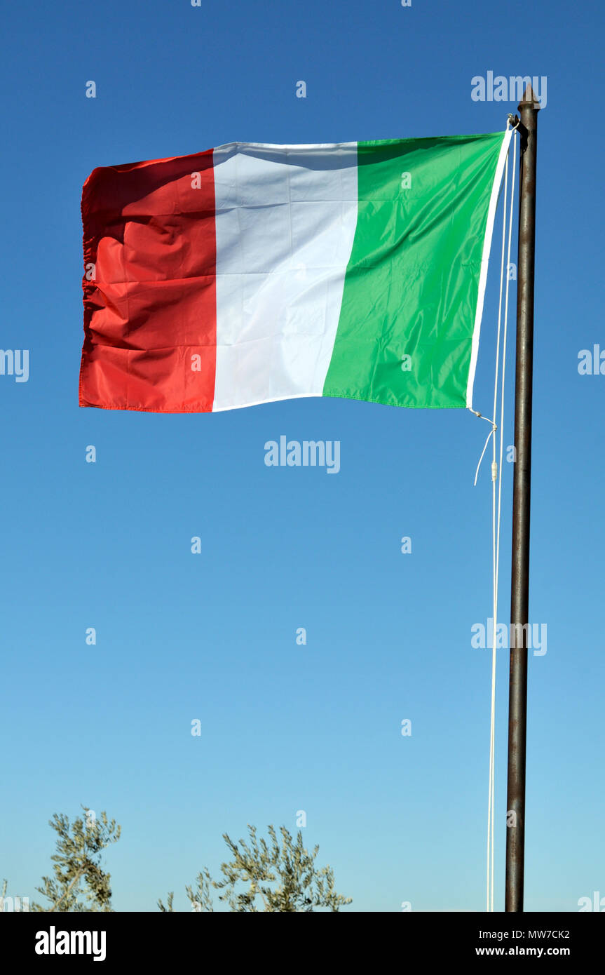 Italian tricolor, flag of Italy, waving with sunny blue sky background ...