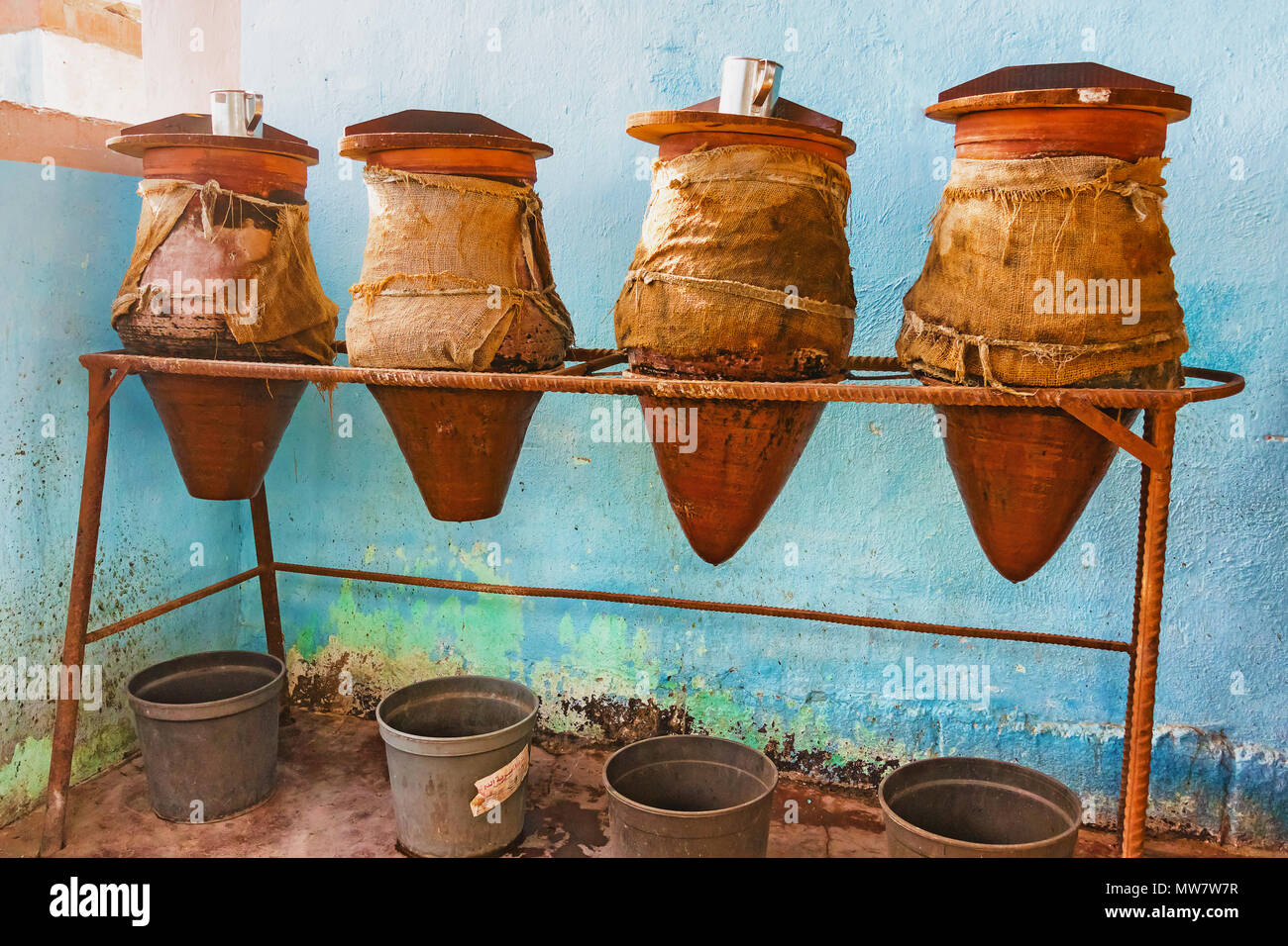 Clay containers with drinking water and old can attach by a cord, which ...