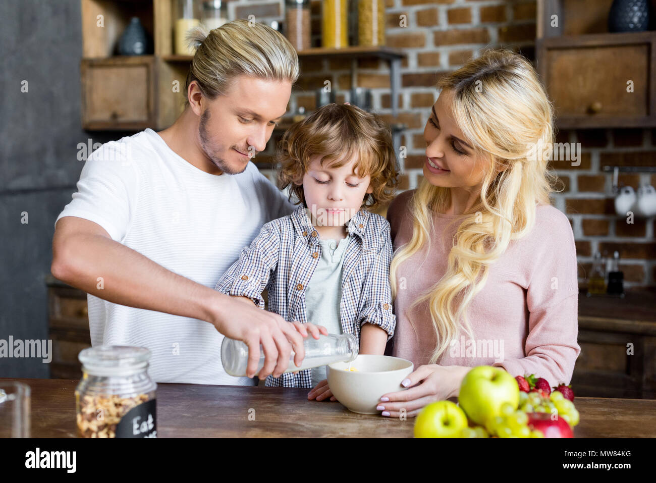 happy young family preparing corn flakes for breakfast at home Stock ...