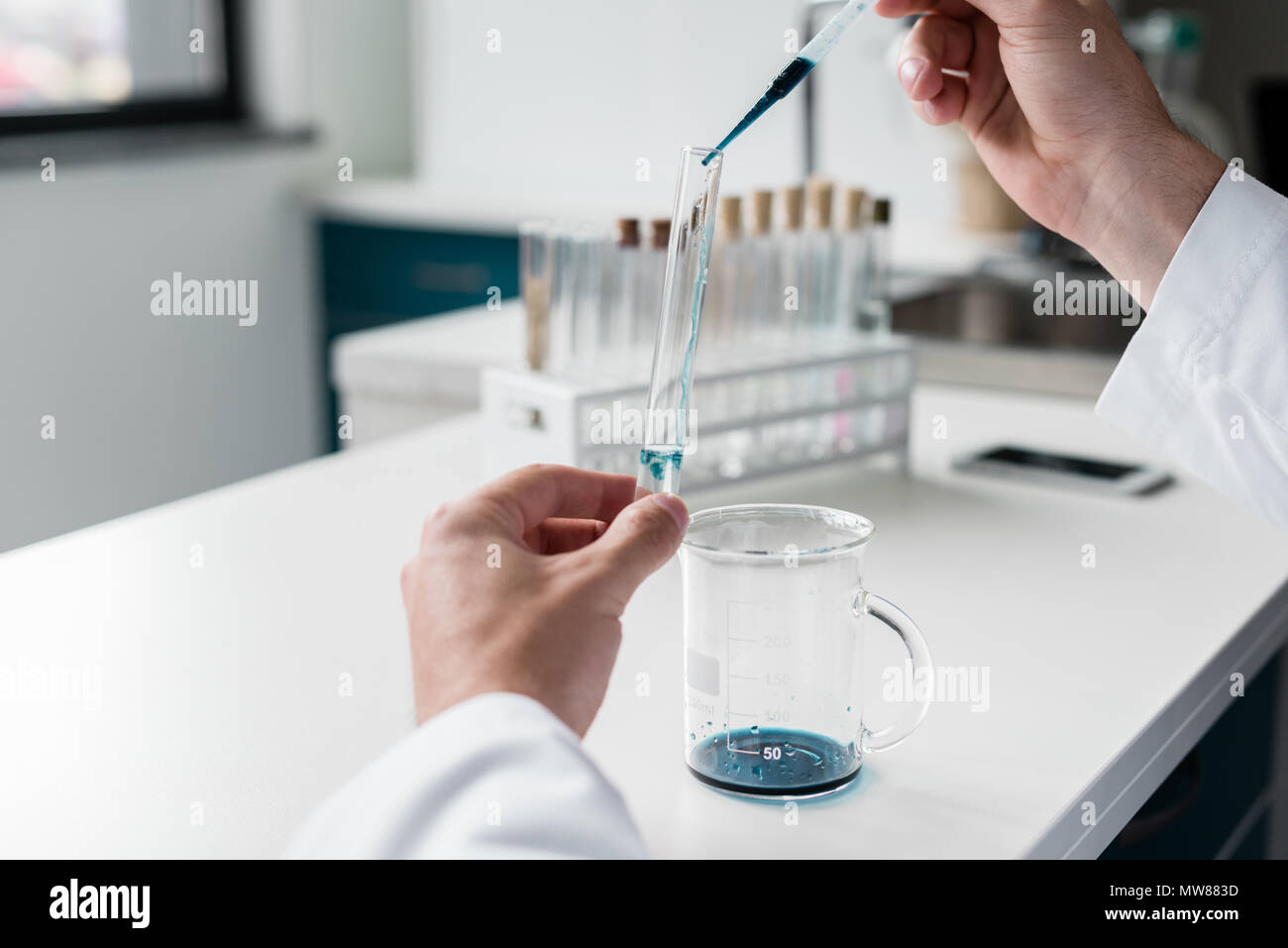 Close-up partial view of scientist making experiment in chemical lab ...