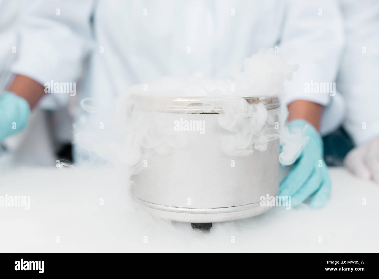 Close-up partial view of scientist making experiment with dry ice in ...