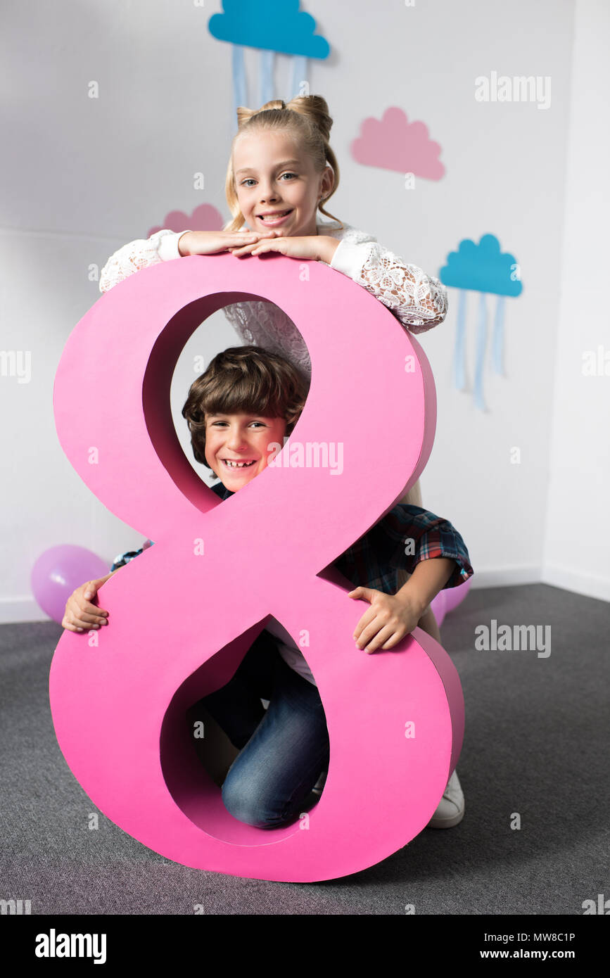 adorable happy kids posing with decorative pink number eight at ...