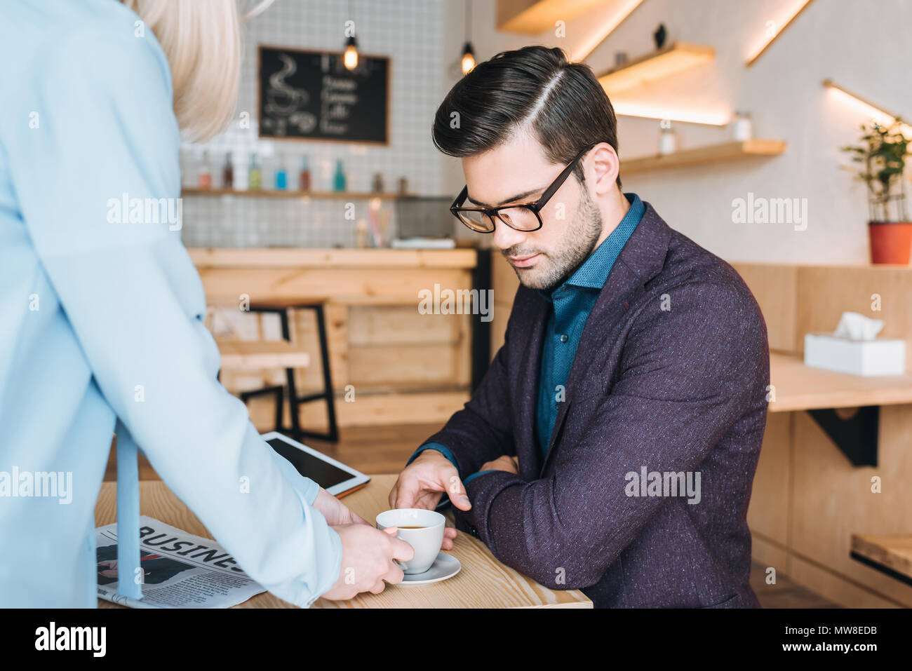 side view of waitress with order for businessman in coffee shop Stock ...