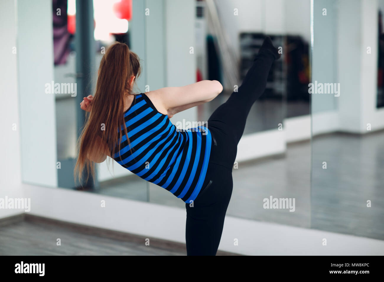 Young woman doing high kick. Fitness in gym Stock Photo - Alamy