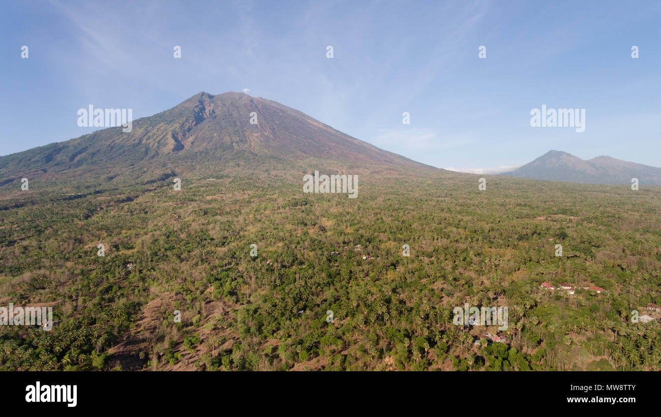 Aerial view of Volcano Mount Agung with smoke billowing out at sunrise ...