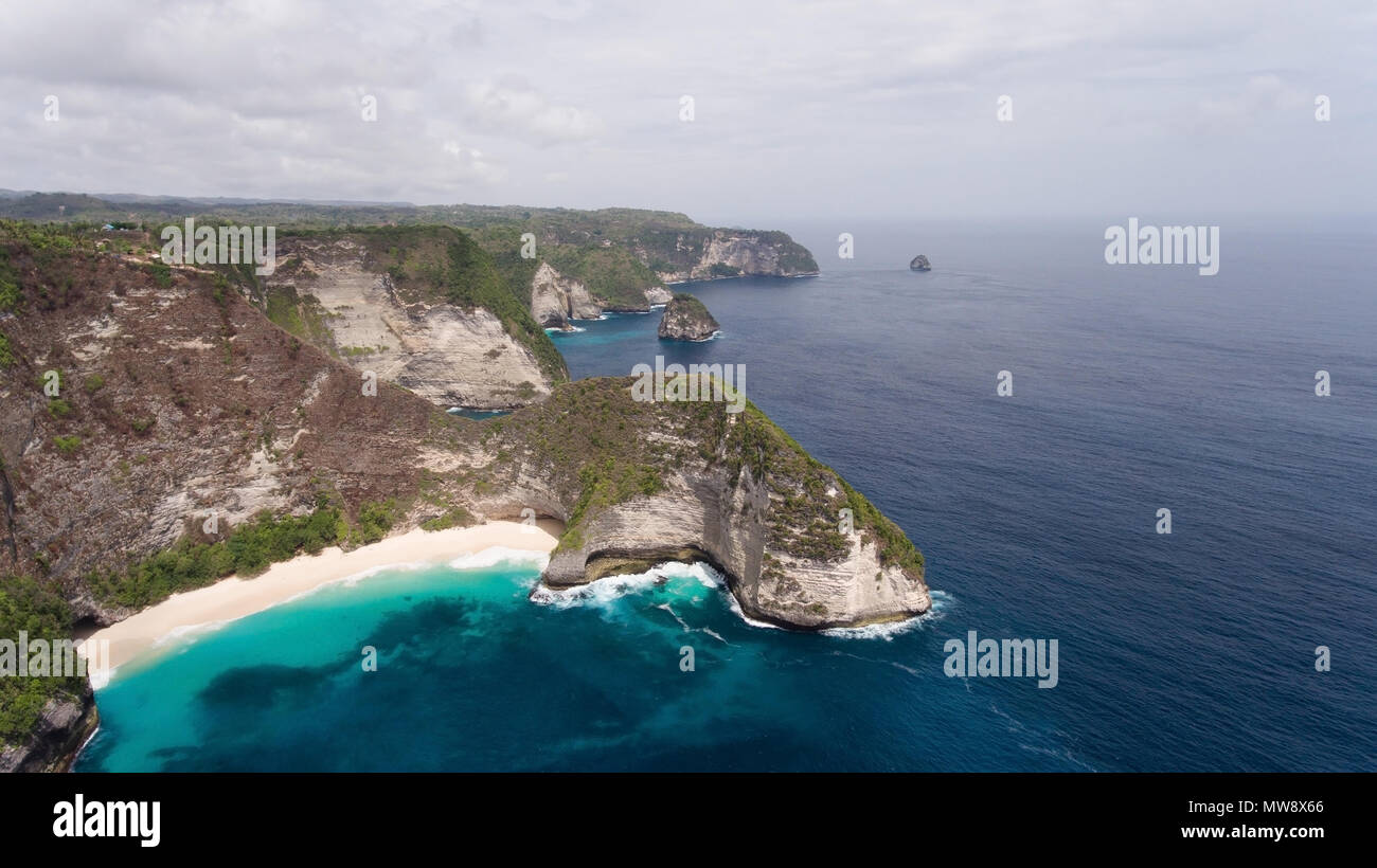 Wild tropical beach at the foot of the cliff. Tropical beach among ...