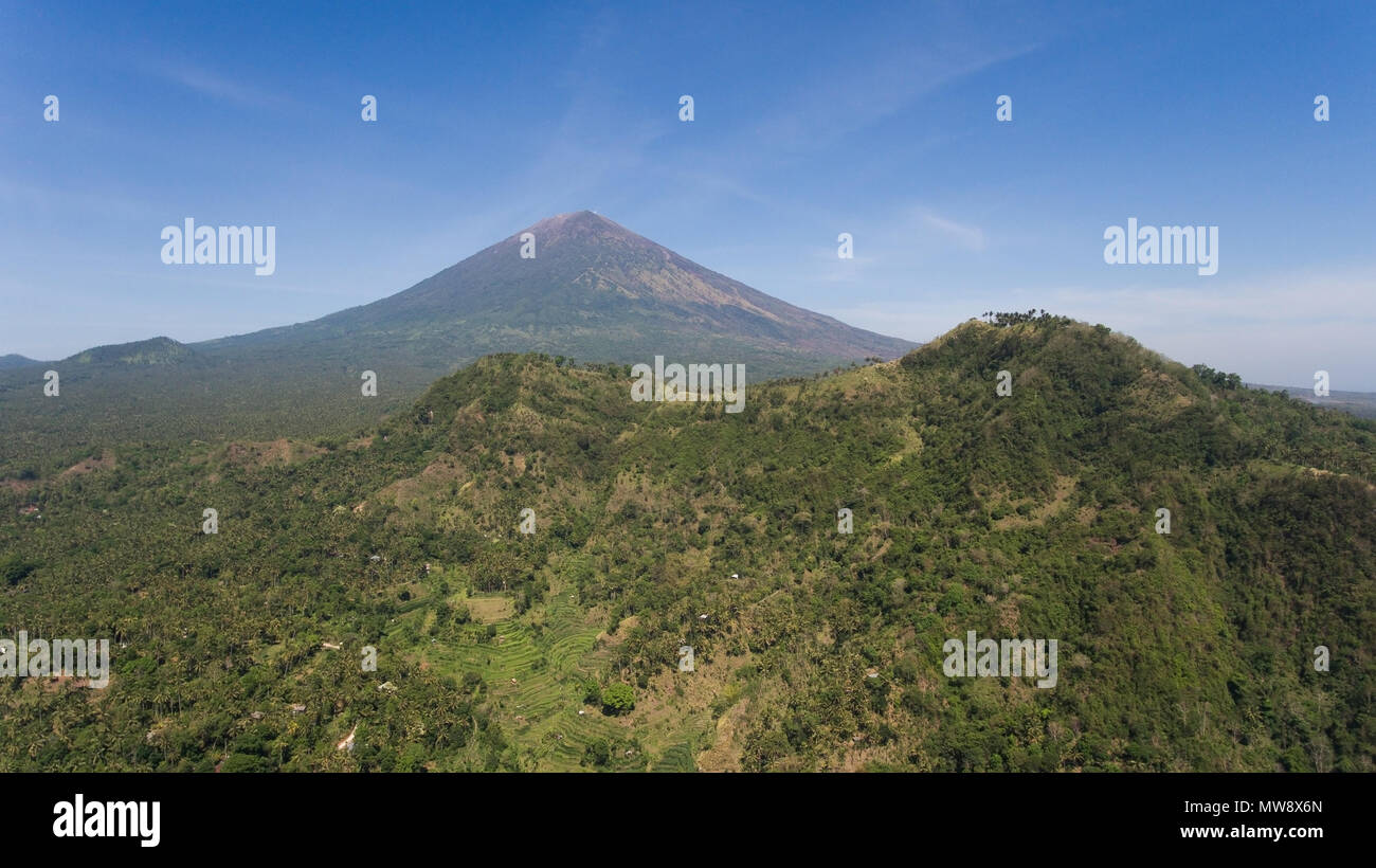 Aerial view of Volcano Mount Agung with smoke billowing out at sunrise ...