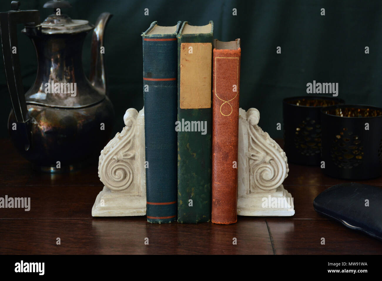 Vintage books enclosed by old fashioned bookends with a moody dark ...