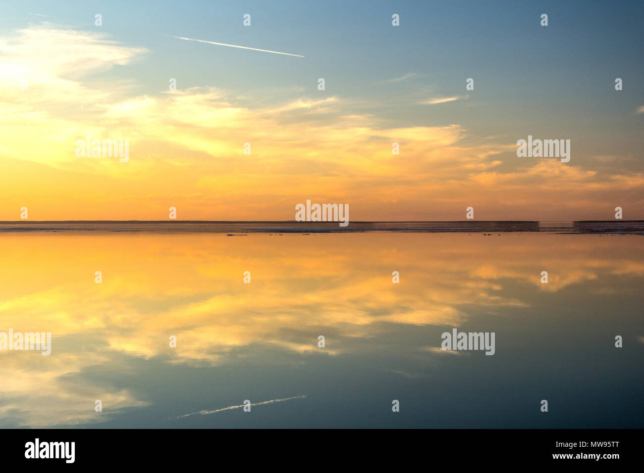 Sea surface with reflection of sky and clouds at sunset Stock Photo - Alamy