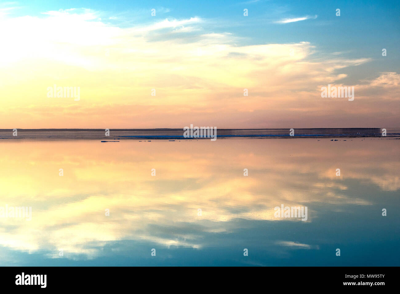 Sea surface with reflection of sky and clouds at sunset Stock Photo - Alamy
