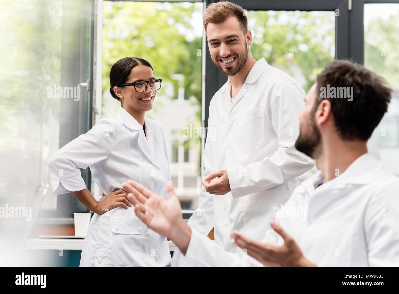 Young researchers talking in laboratory hi-res stock photography and ...