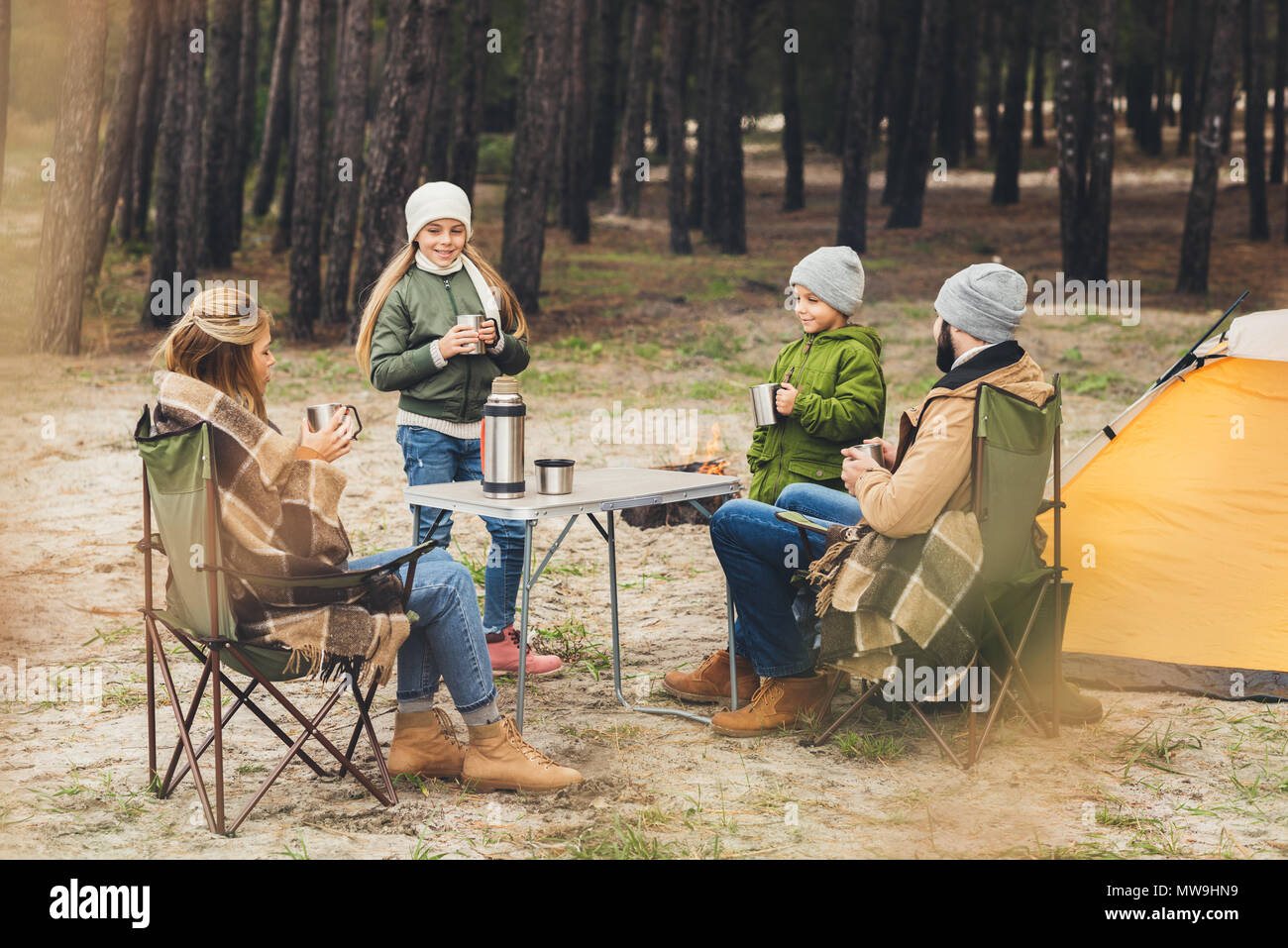 happy family drinking hot tea while having camping trip Stock Photo - Alamy
