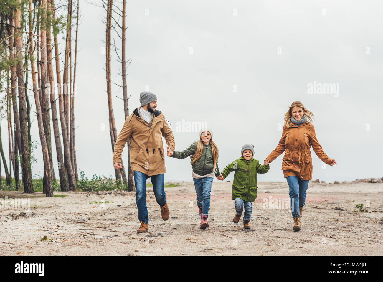 beautiful happy family running together and holding hands on nature ...