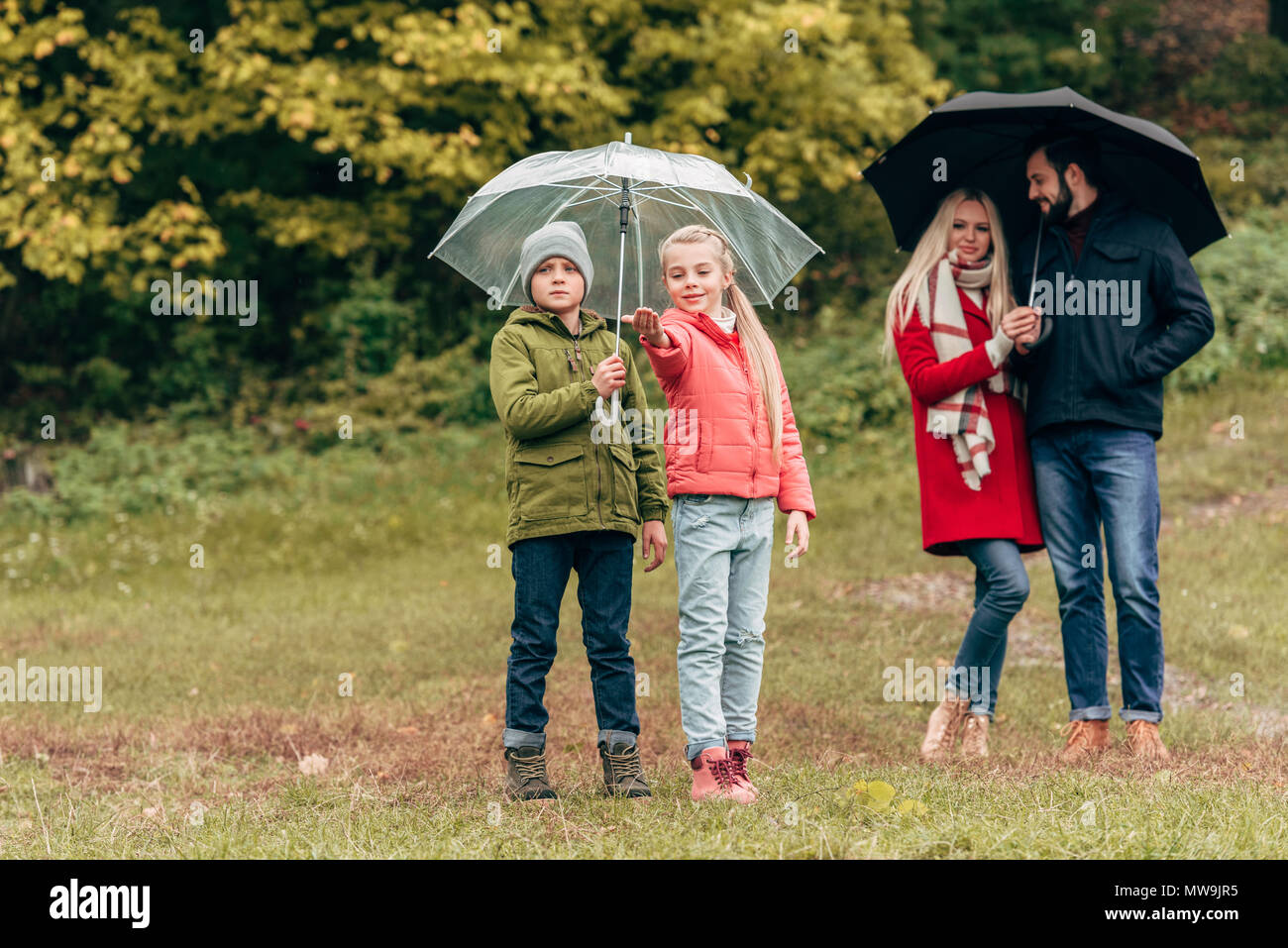 Young children holding umbrellas in rain hi-res stock photography and ...