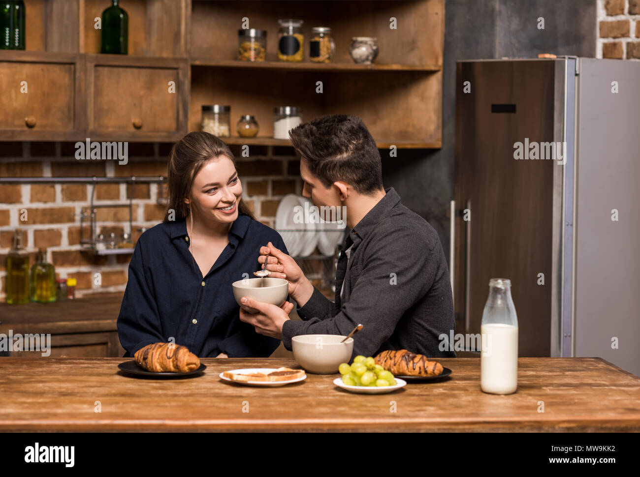 boyfriend asking girlfriend to taste breakfast in kitchen Stock Photo ...