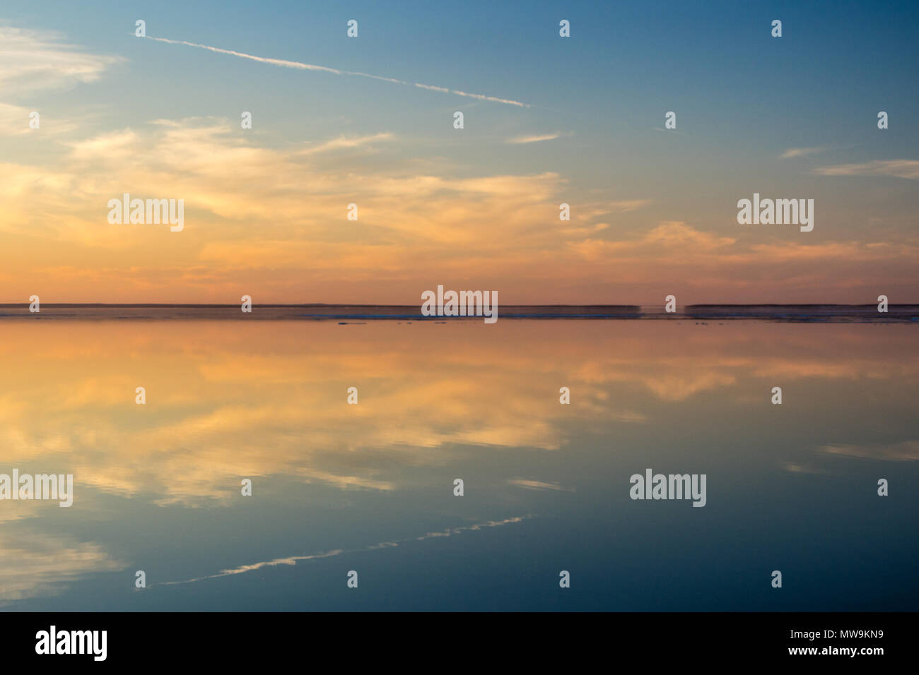 Sea surface with reflection of sky and clouds at sunset Stock Photo - Alamy