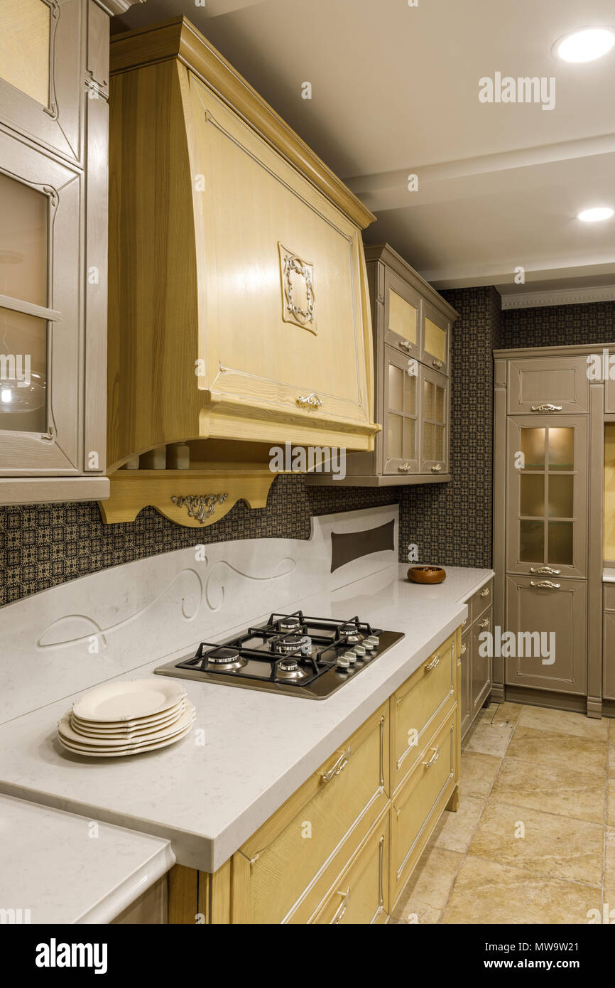 Interior of modern kitchen with plates on counter by stove Stock Photo ...