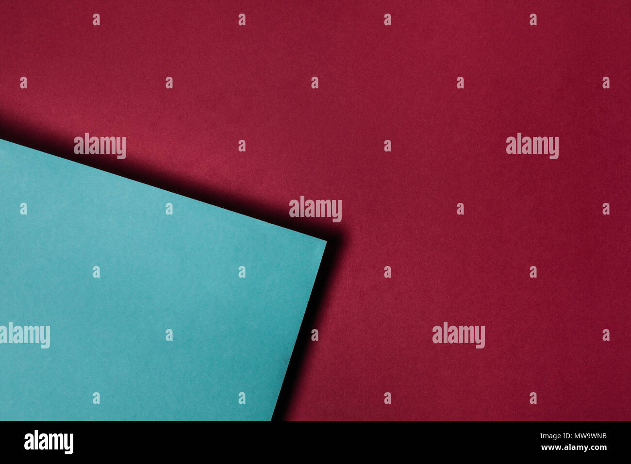 turquoise paper sheet on maroon background Stock Photo - Alamy