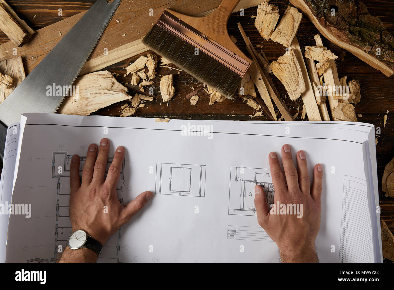 cropped shot of architect hands on blueprint at table with paintbrush ...