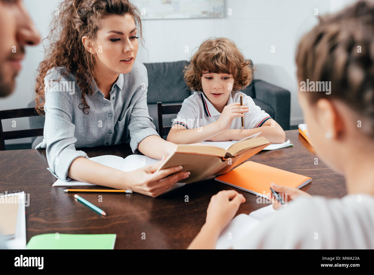 pensive young parents doing homework with kids Stock Photo - Alamy