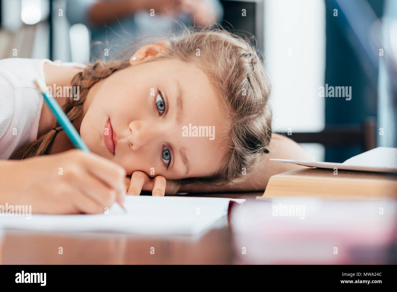 sad little girl writing homework Stock Photo - Alamy