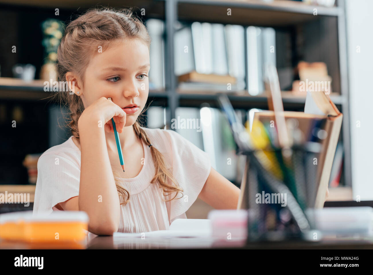 focused cute little girl doing homework Stock Photo - Alamy