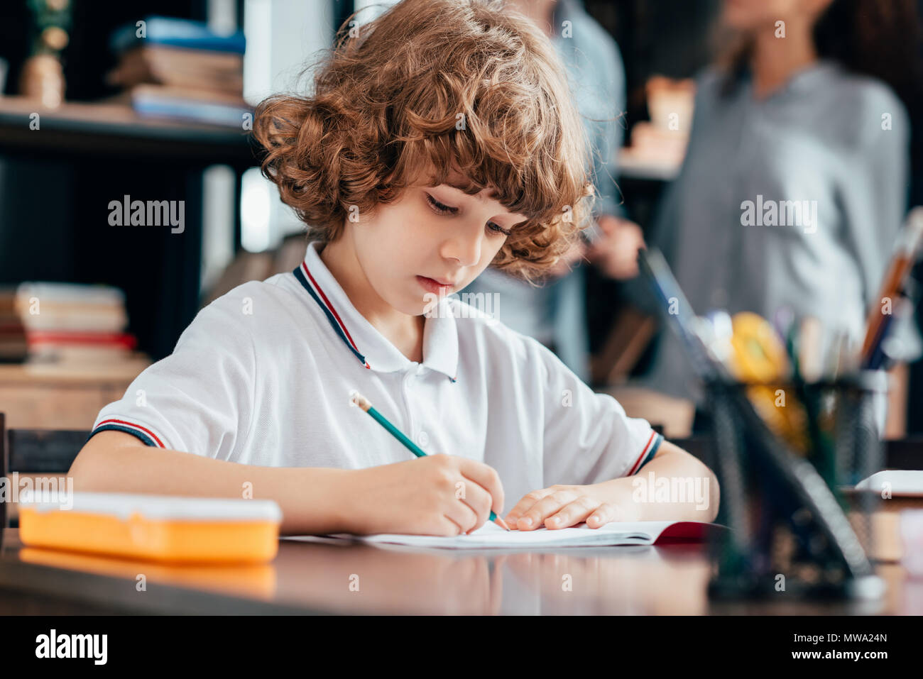 adorable curly boy doing homework Stock Photo - Alamy