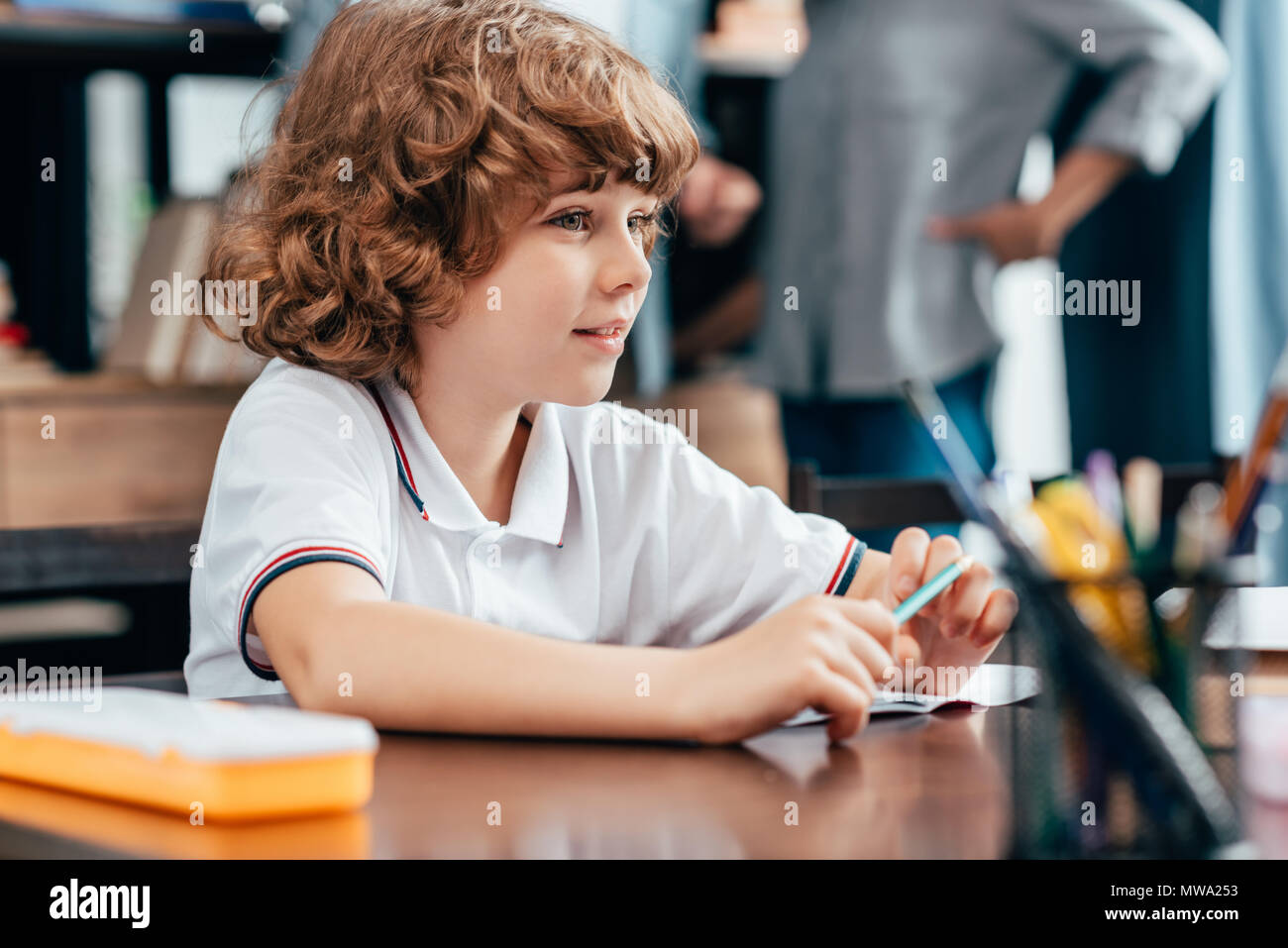 cute little boy sitting at school desk Stock Photo - Alamy