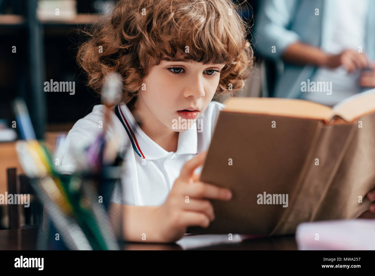 little boy reading book for homework Stock Photo - Alamy