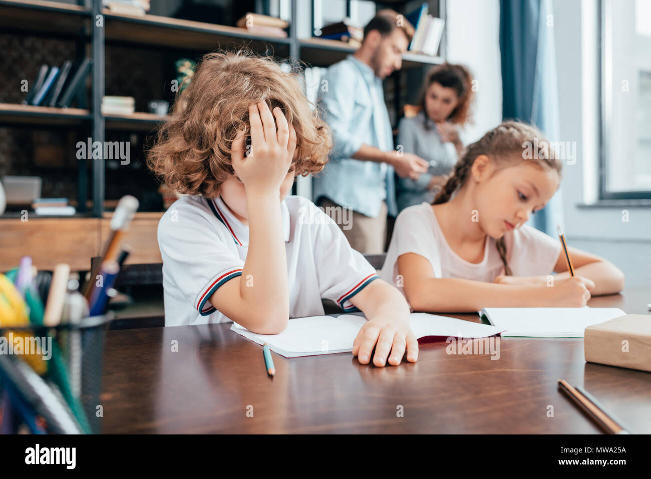 exhausted little kids doing homework together Stock Photo - Alamy