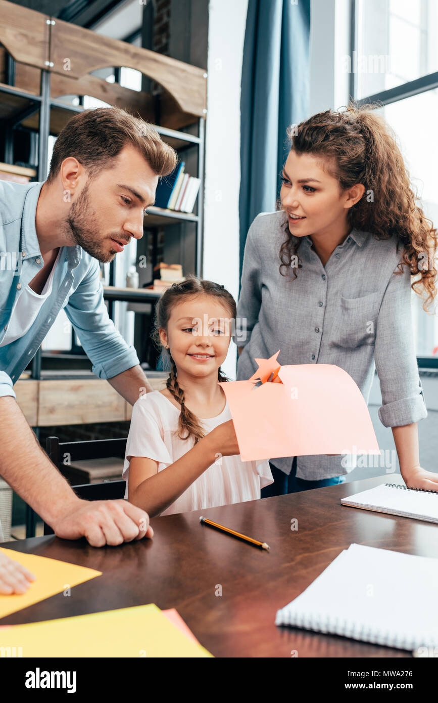 beautiful young parents doing homework with daughter Stock Photo - Alamy