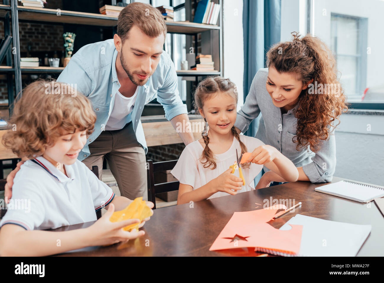 happy young parents doing homework with kids Stock Photo - Alamy