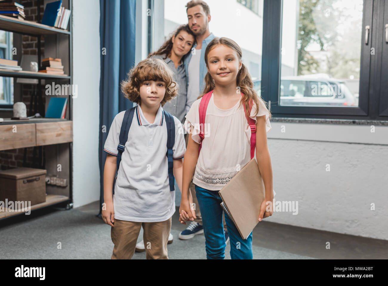 kids ready for school with parents on background Stock Photo - Alamy