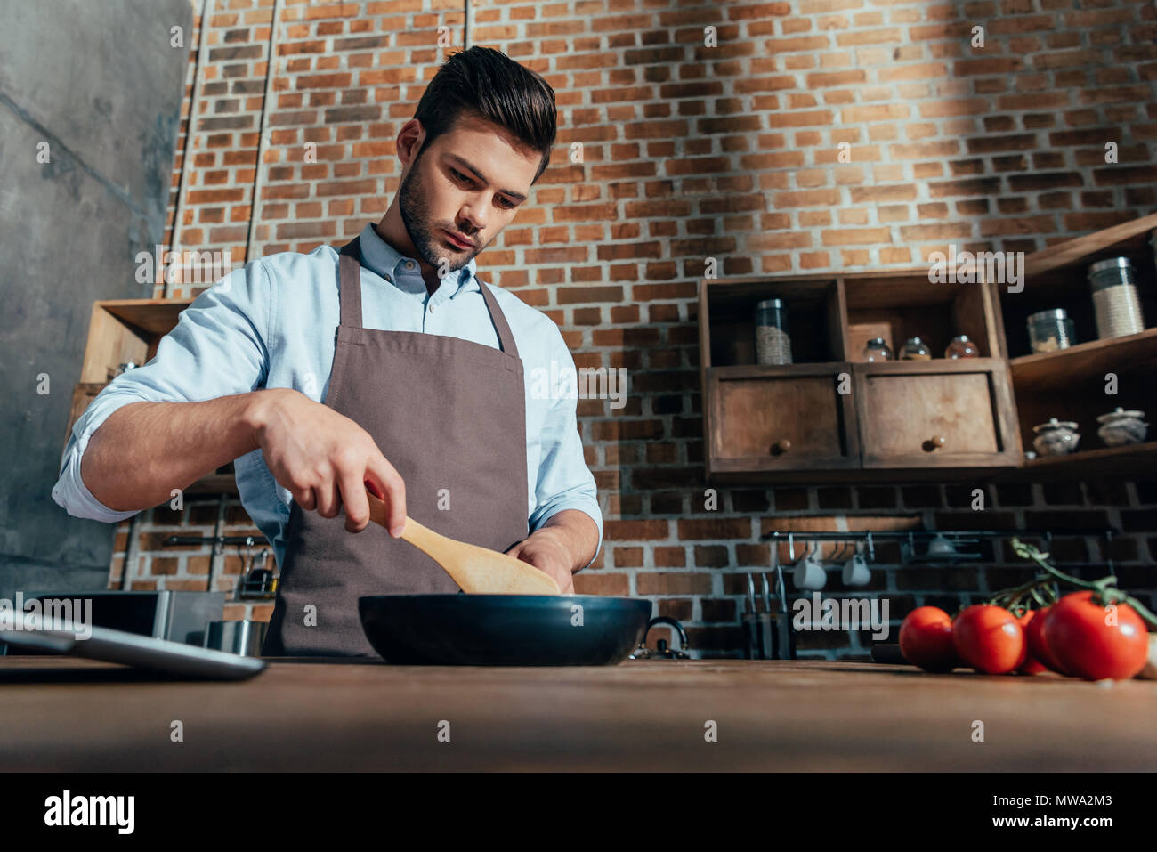 Young man cooking hi-res stock photography and images - Alamy