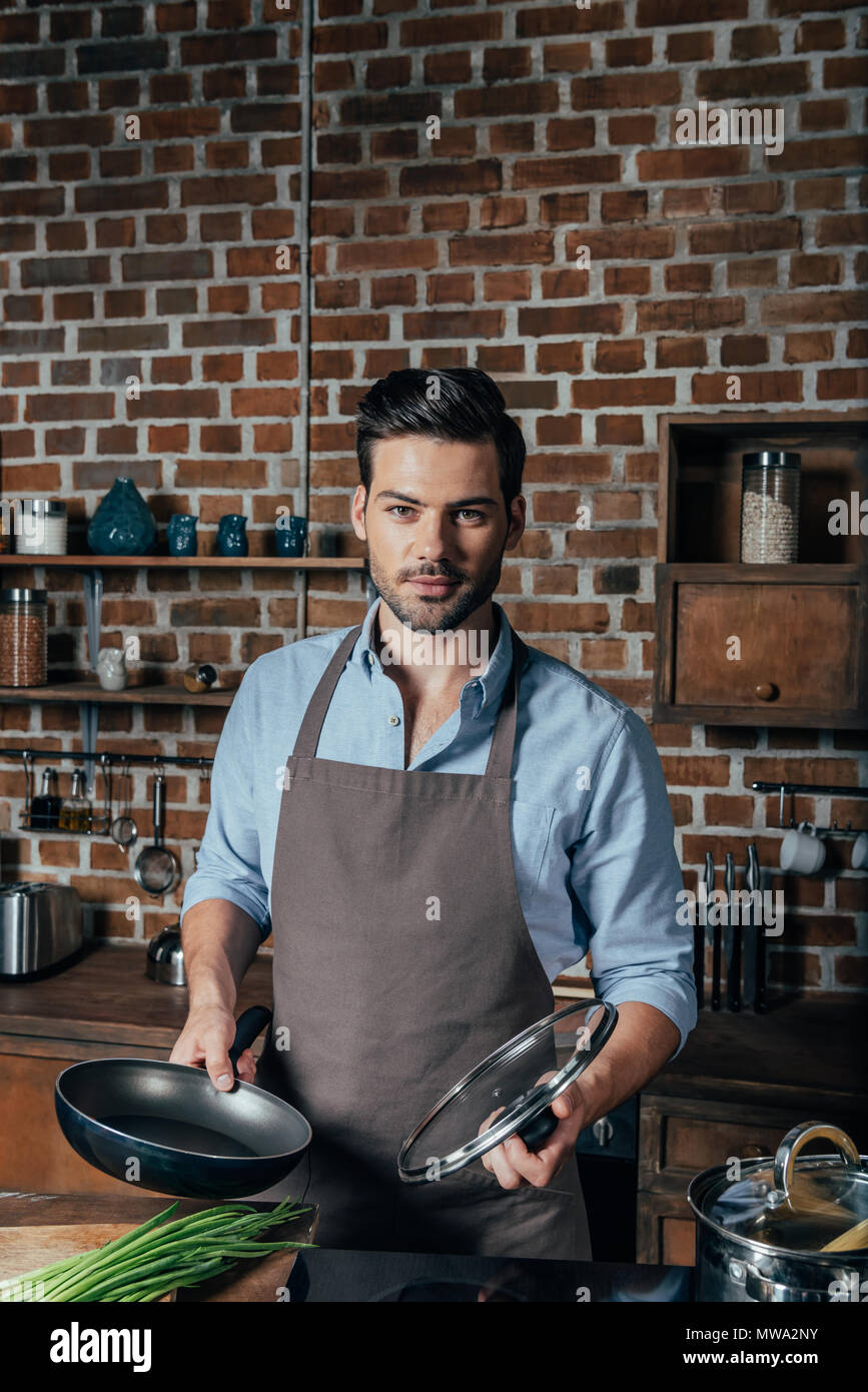 handsome young man with frying pan in kitchen Stock Photo - Alamy