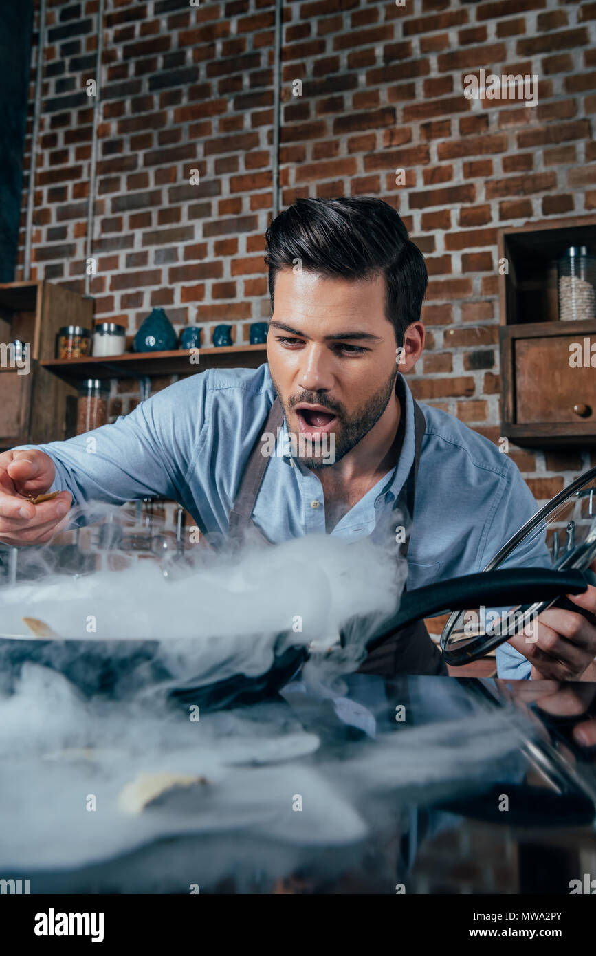 excited young man with apron cooking Stock Photo - Alamy