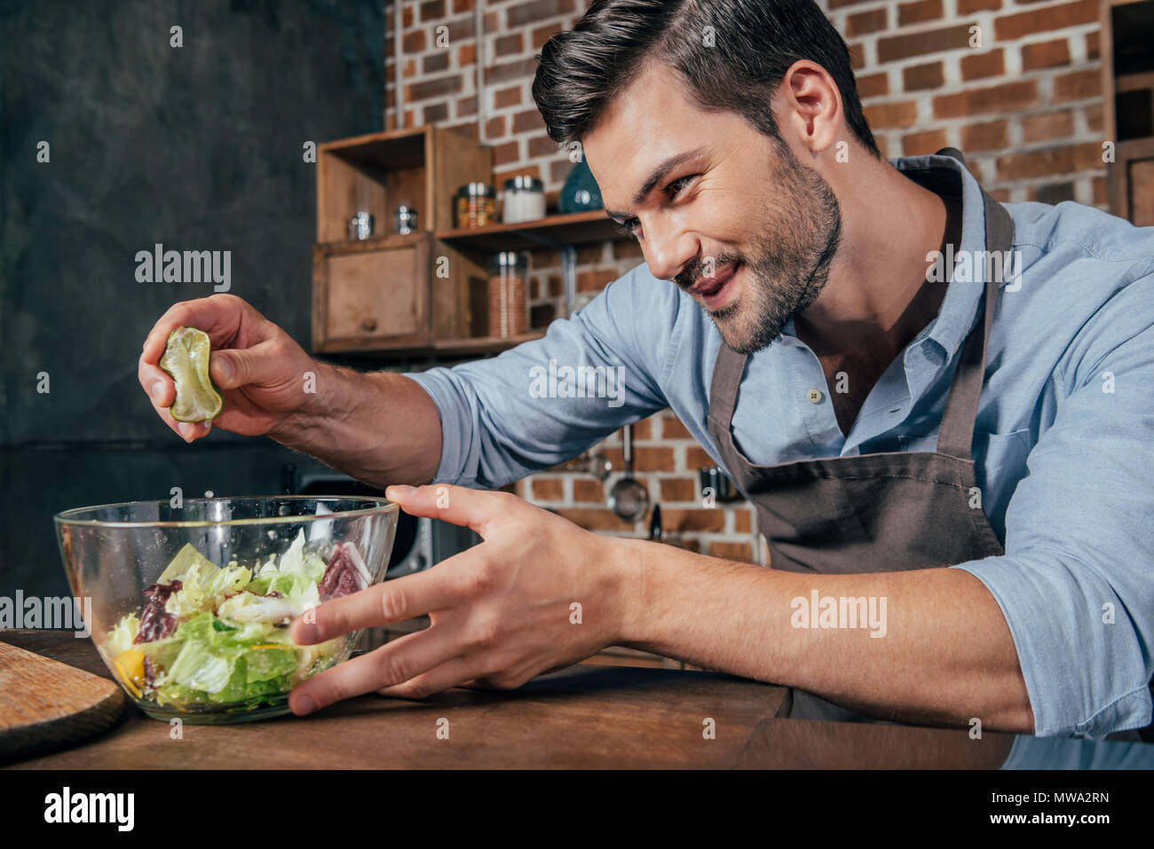 excited young man making salad Stock Photo - Alamy