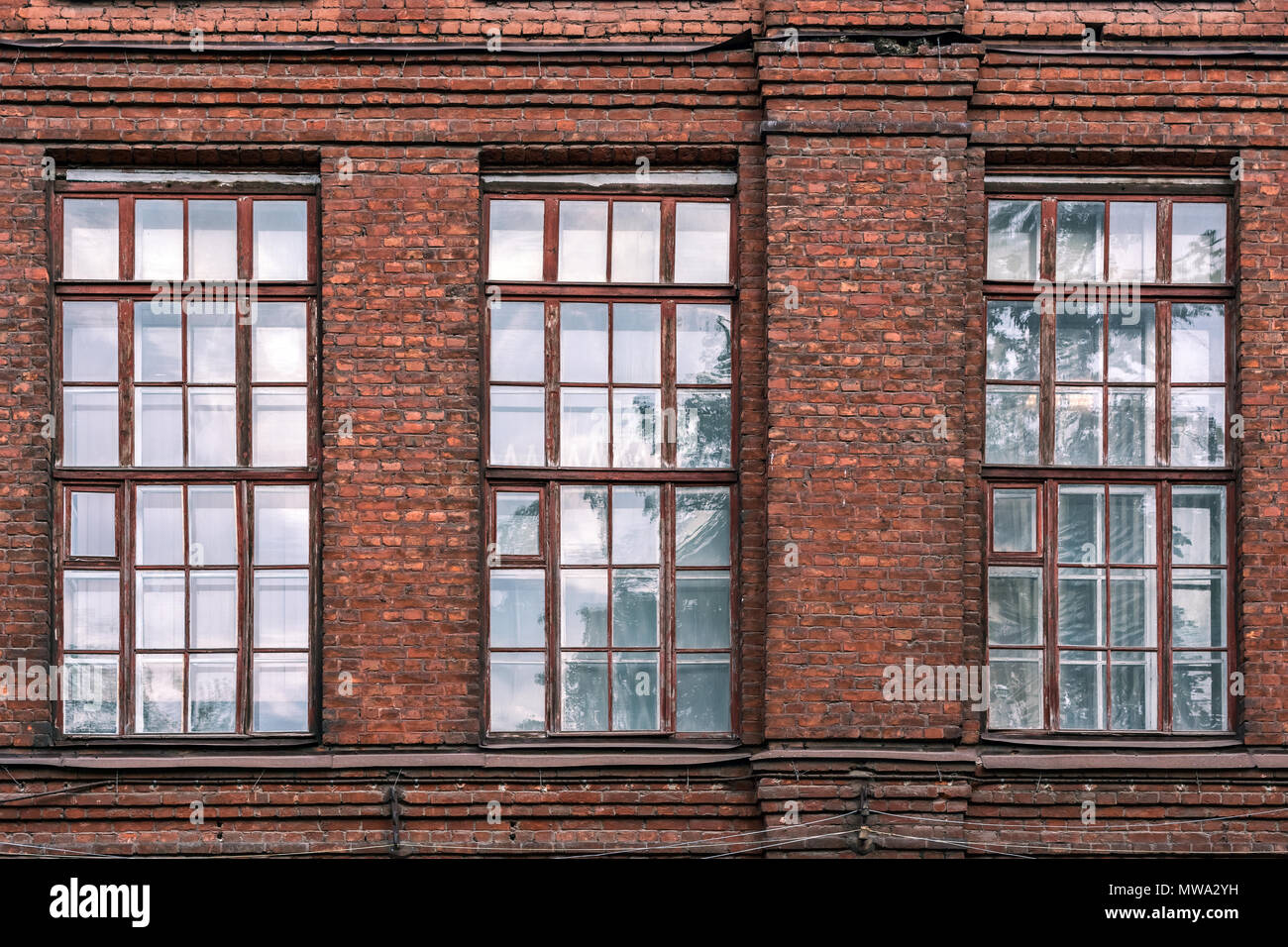 Three large windows on the facade of a red brick building Stock Photo ...