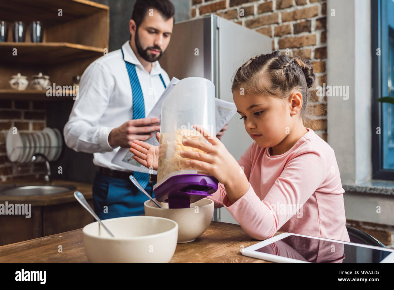 sad daughter pouring cereal in bowl for father on breakfast Stock Photo ...