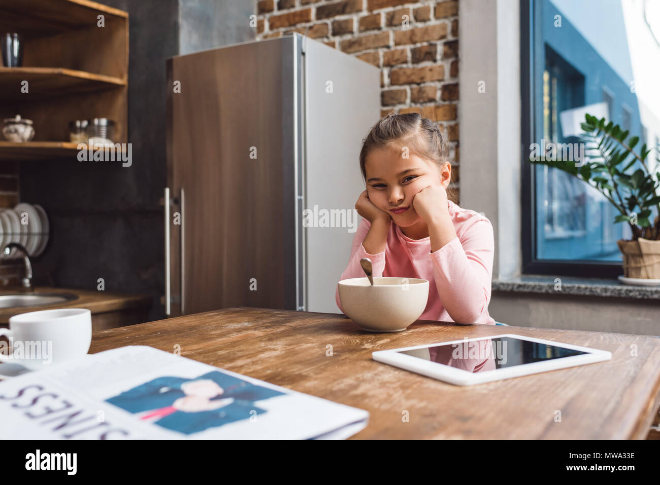 bored little child with bowl of breakfast sitting on kitchen Stock ...