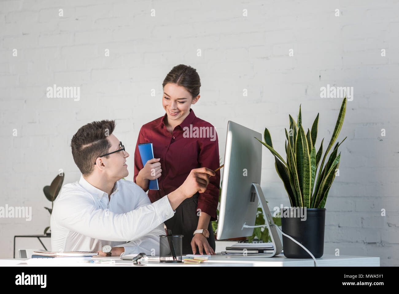 young managers working with computer together at workplace in modern ...