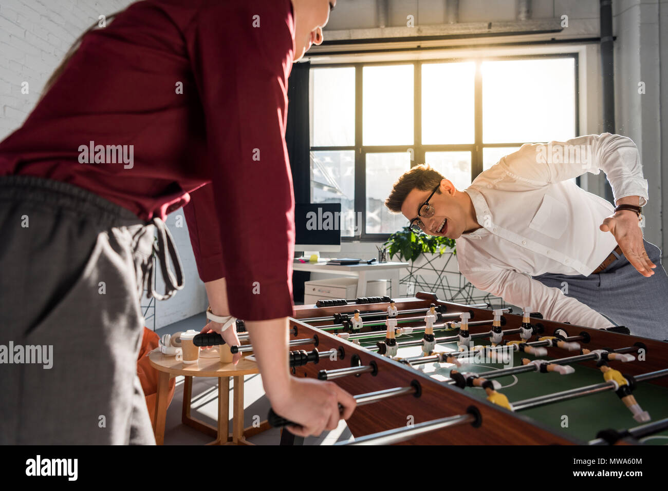 happy colleagues playing table football at modern office Stock Photo ...
