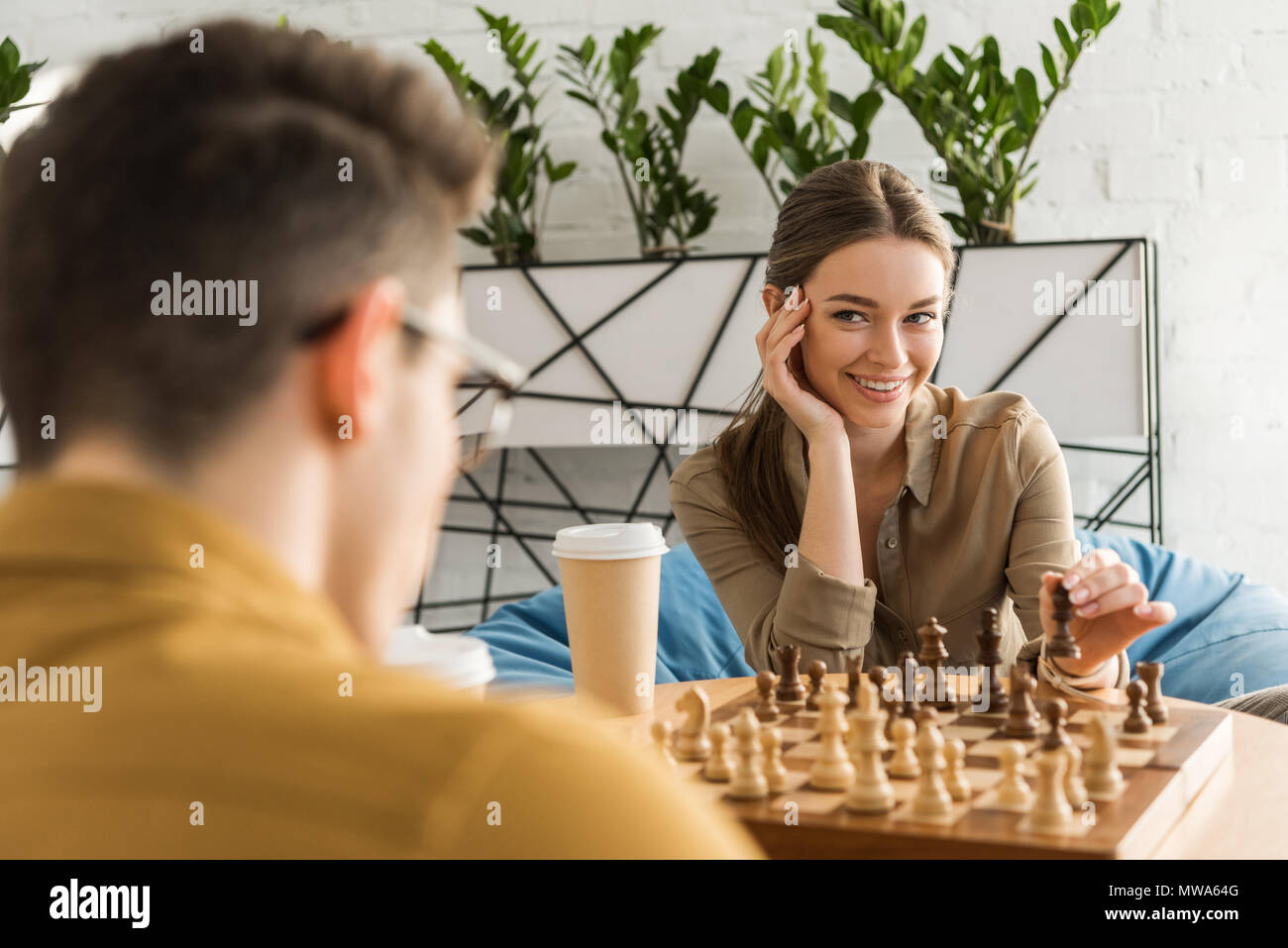 young woman playing chess and flirting with opponent Stock Photo - Alamy