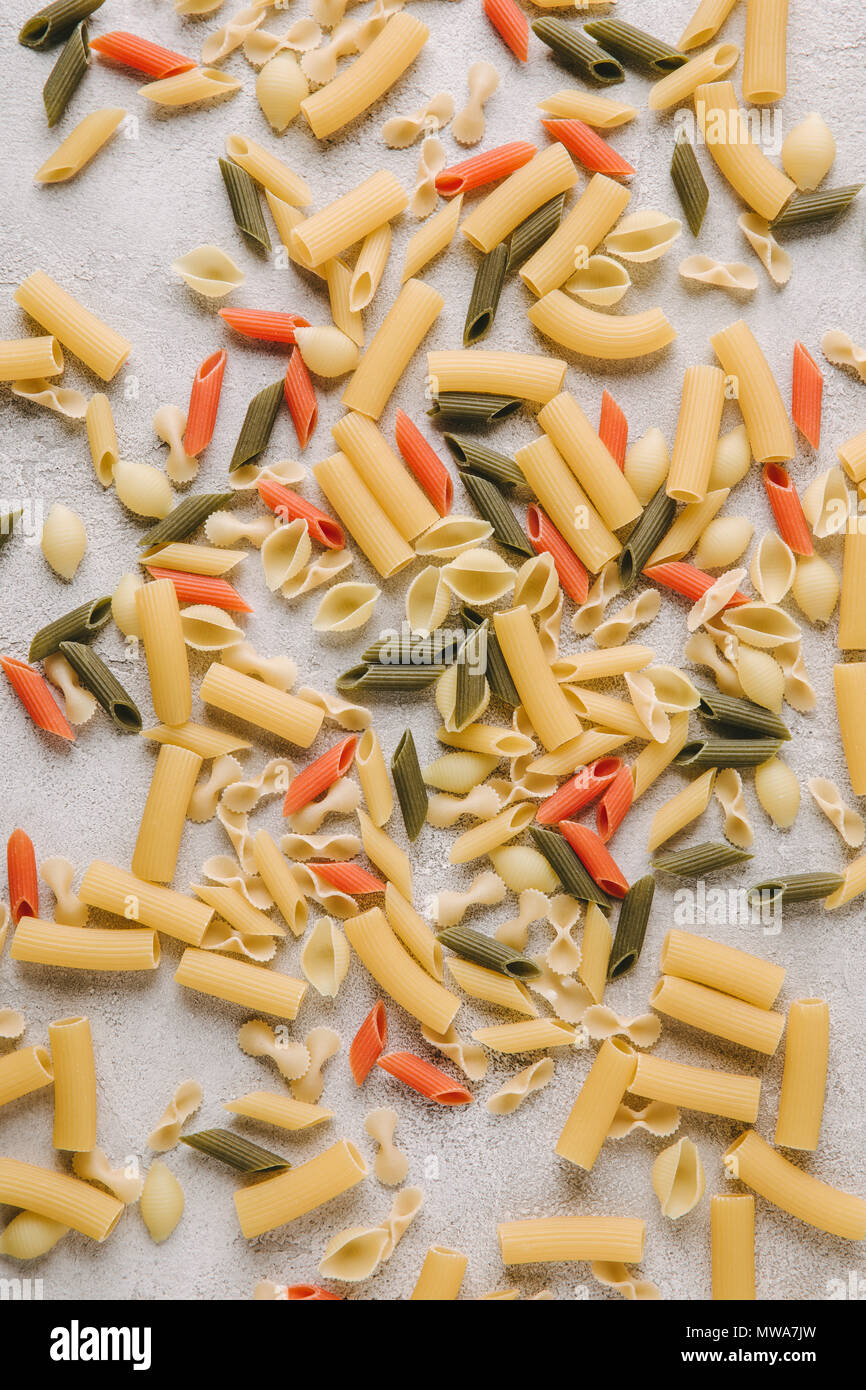 top view of various raw pasta spilled on concrete surface Stock Photo ...