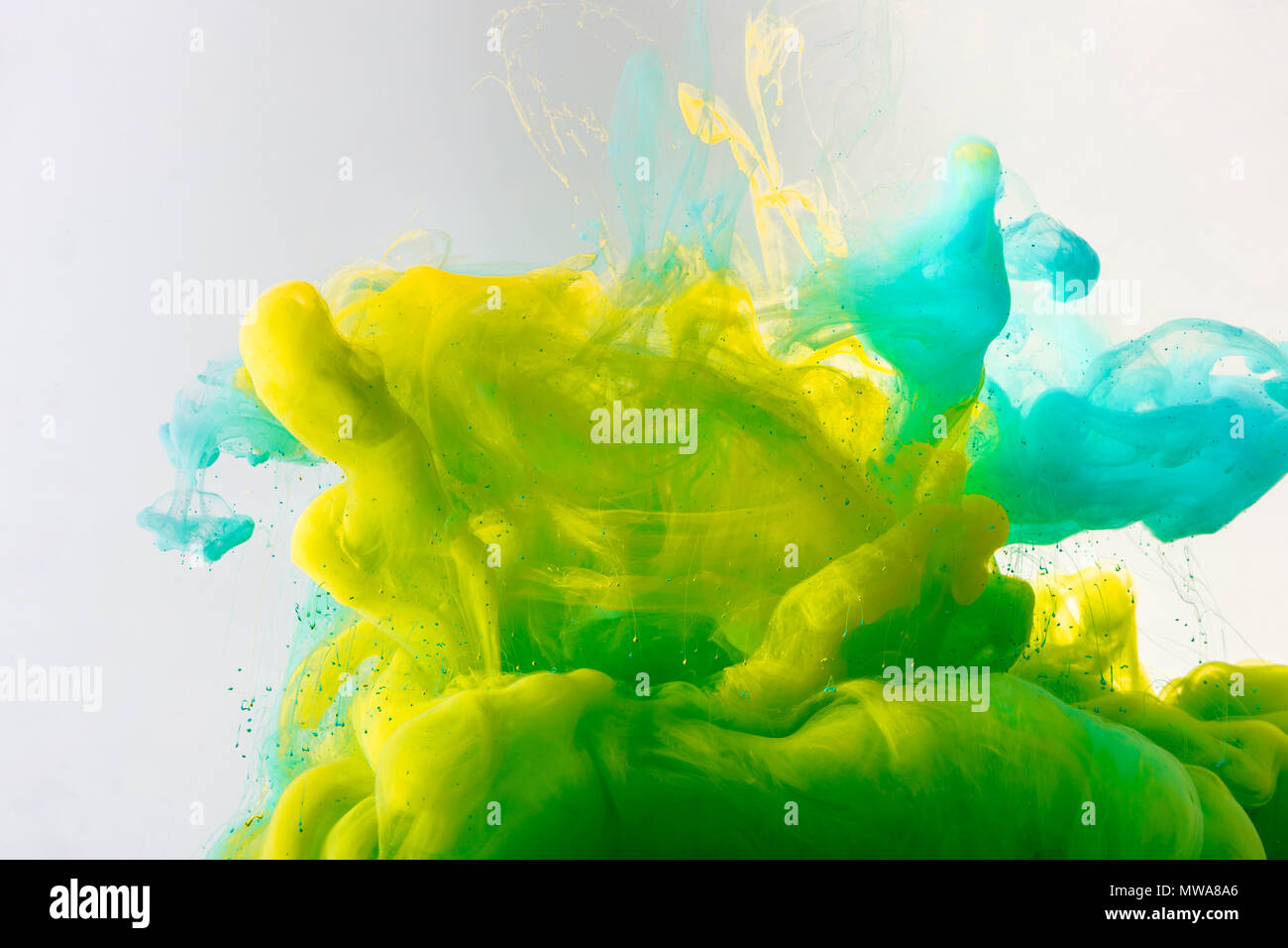 design with flowing turquoise, yellow and green paint in water ...